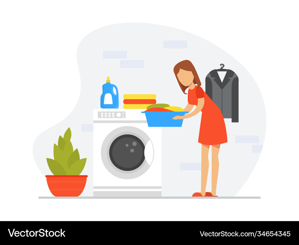 Young woman loading clothes for washing in laundry